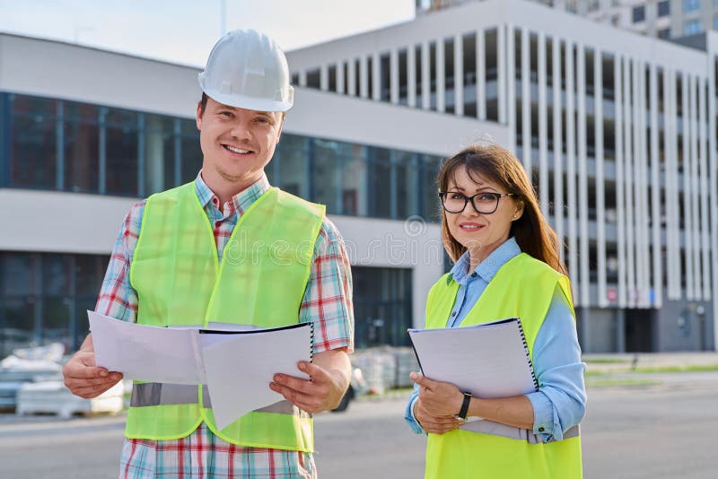 Two Industrial Workers Looking at Camera, Outdoors on Construction Site Stock Image - Image of ...
