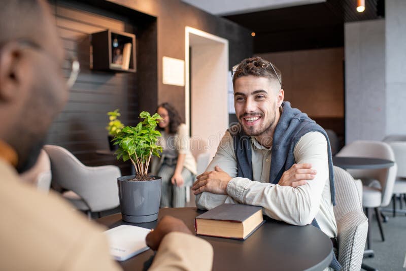 Two Intercultural Students Having Discussion by Table in Cafe Stock ...