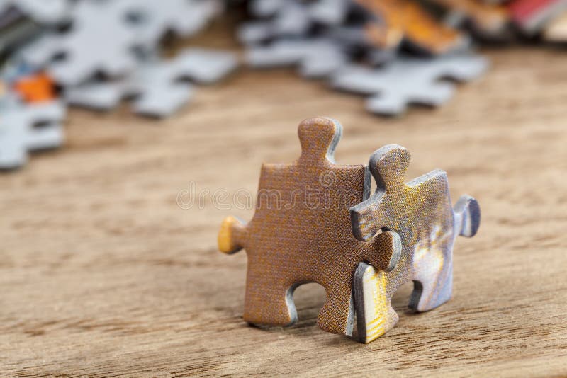Two Jigsaw Puzzle Pieces on Table Stock Image - Image of holding ...
