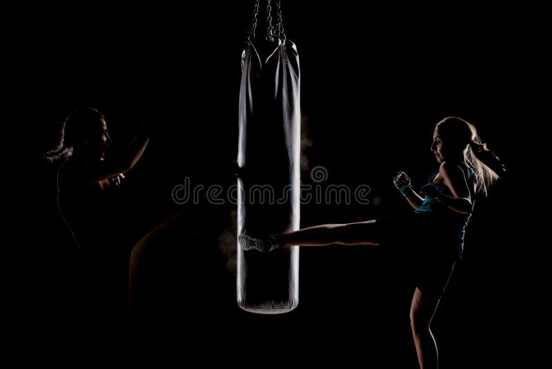 Two Kick Fighter Girls Punching a Boxing Bag Stock Photo - Image of ...