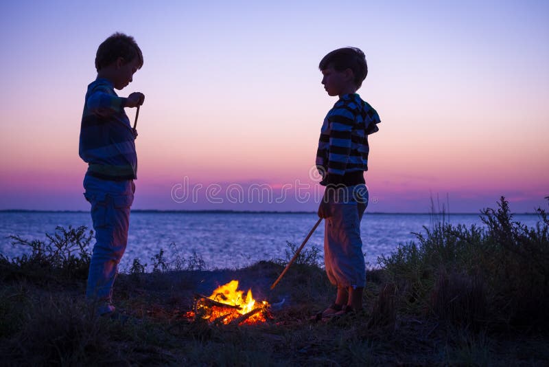 Two Kids on the Beach with Campfire at Sunset Stock Photo - Image of ...