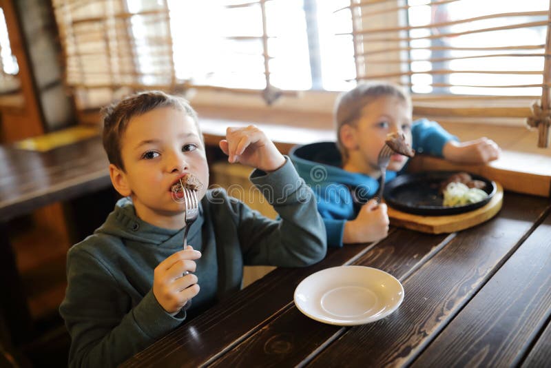 Two Kids Have Lunch in Restaurant Stock Photo - Image of knife ...