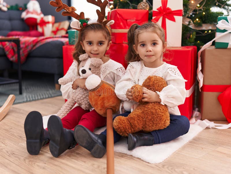 Two Kids Holding Teddy Bear Sitting on Floor by Christmas Tree at Home ...