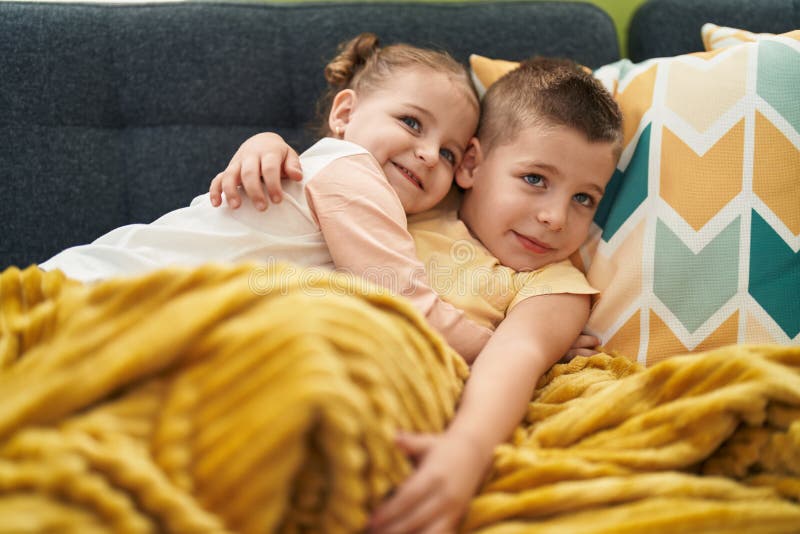 Two Kids Hugging Each Other Lying on Sofa at Home Stock Image - Image ...