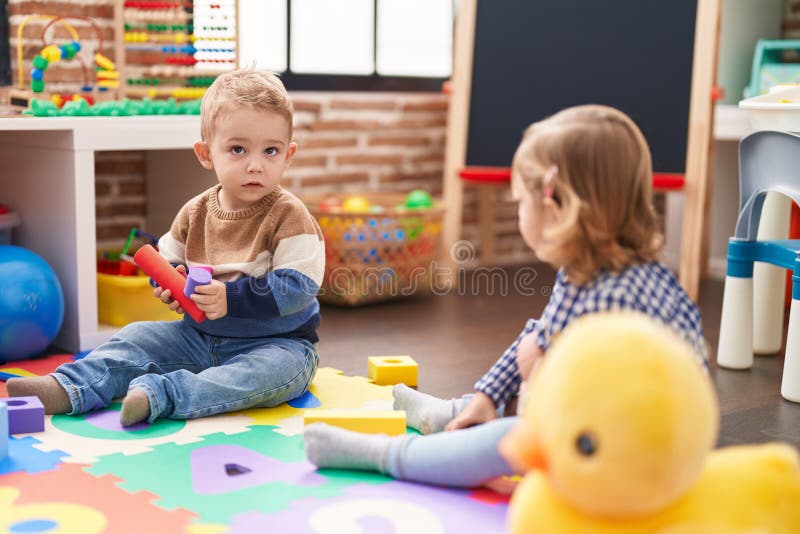 Two Kids Playing with Construction Blocks Sitting on Floor at ...