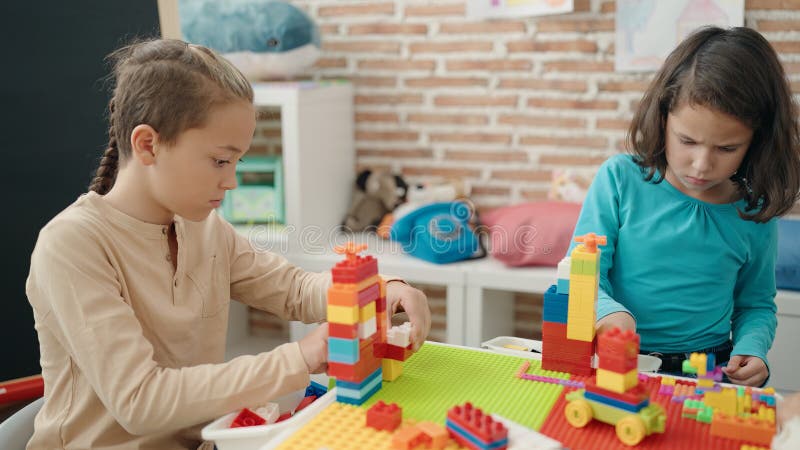 Two Kids Playing with Construction Blocks Sitting on Table at ...