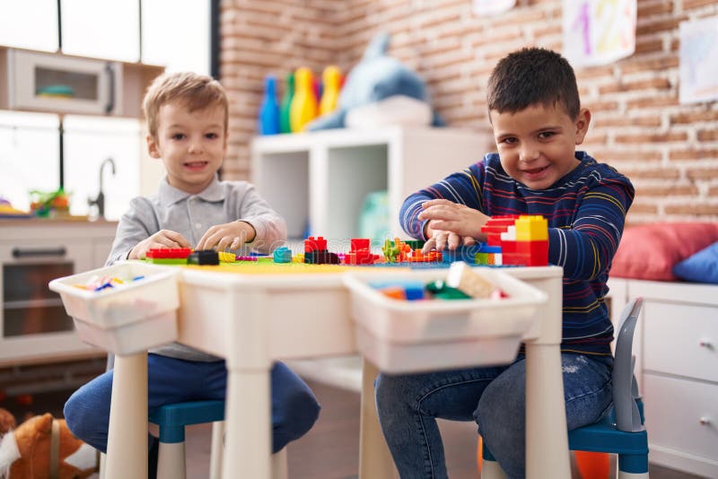 Two Kids Playing with Construction Blocks Sitting on Table at ...