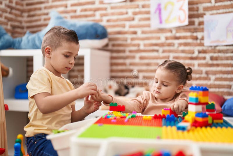 Two Kids Playing with Construction Blocks Sitting on Table at ...