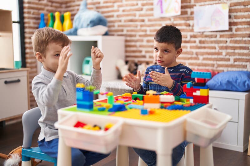 Two Kids Playing with Construction Blocks Sitting on Table at ...