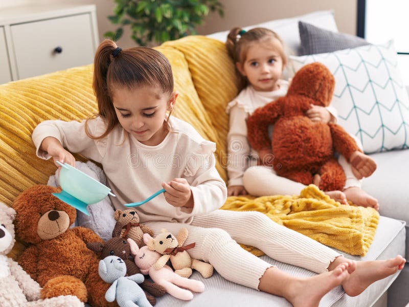 Two Kids Playing with Dolls Sitting on Sofa at Home Stock Image - Image ...