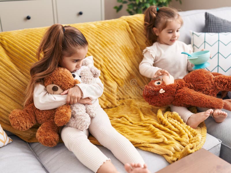 Two Kids Playing with Dolls Sitting on Sofa at Home Stock Photo - Image ...
