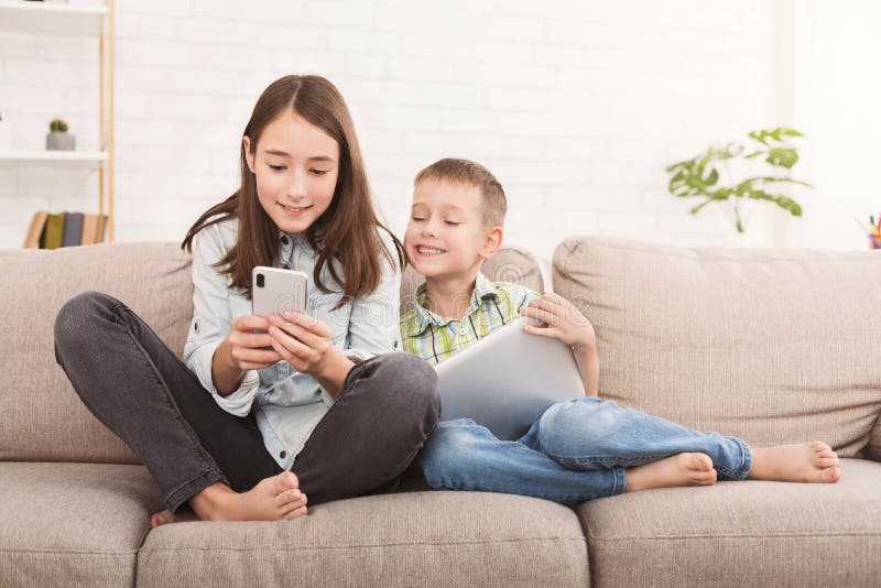 Two Kids Playing on Gadget on Sofa at Home Stock Photo - Image of ...