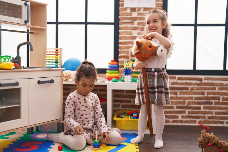Two Kids Playing with Hoops and Horse Toy at Kindergarten Stock Photo ...