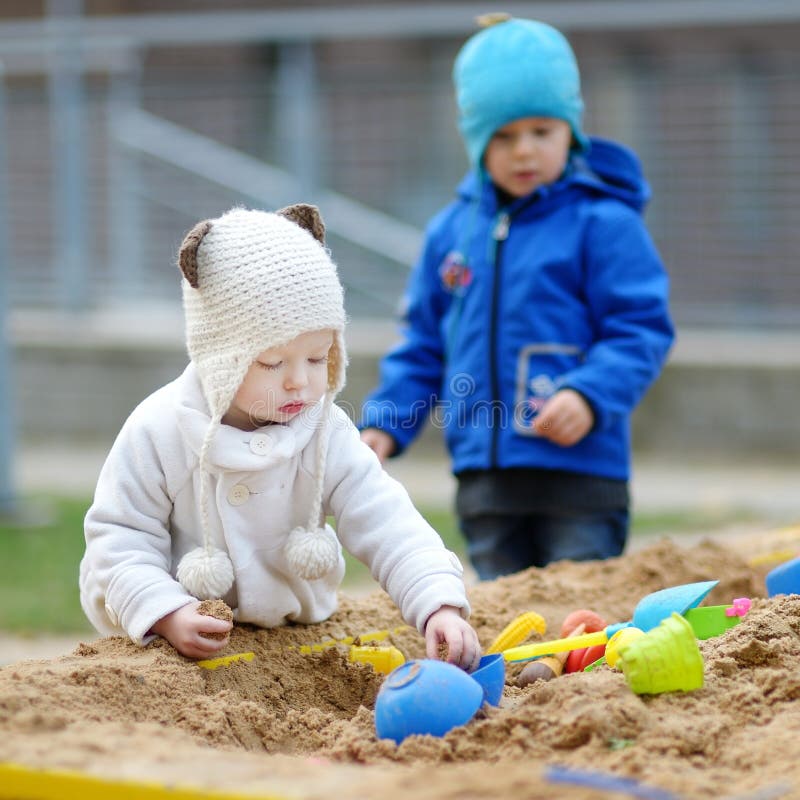 Two Kids Playing in a Sandbox Stock Photo - Image of face, colorful ...