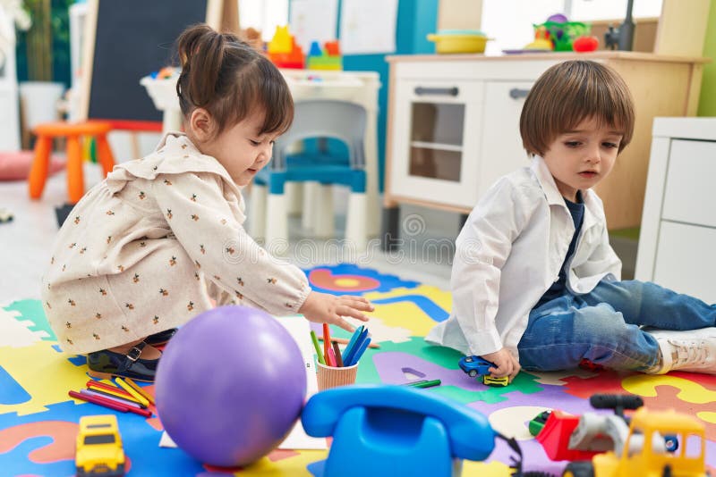 Two Kids Playing with Toys Sitting on Floor at Kindergarten Stock Photo ...