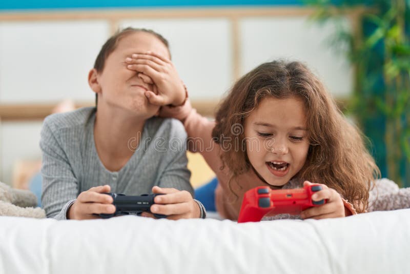 Two Kids Playing Video Game Lying on Bed Cheating at Bedroom Stock ...