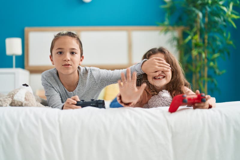 Two Kids Playing Video Game Lying on Bed Cheating at Bedroom Stock ...