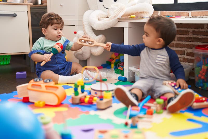 Two Kids Playing Xylophone and Maraca Sitting on Floor at Kindergarten ...