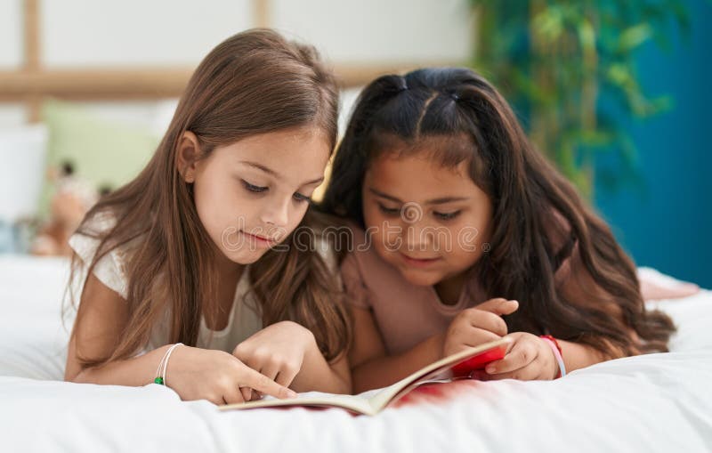 Two Kids Reading Book Lying on Bed at Bedroom Stock Photo - Image of ...
