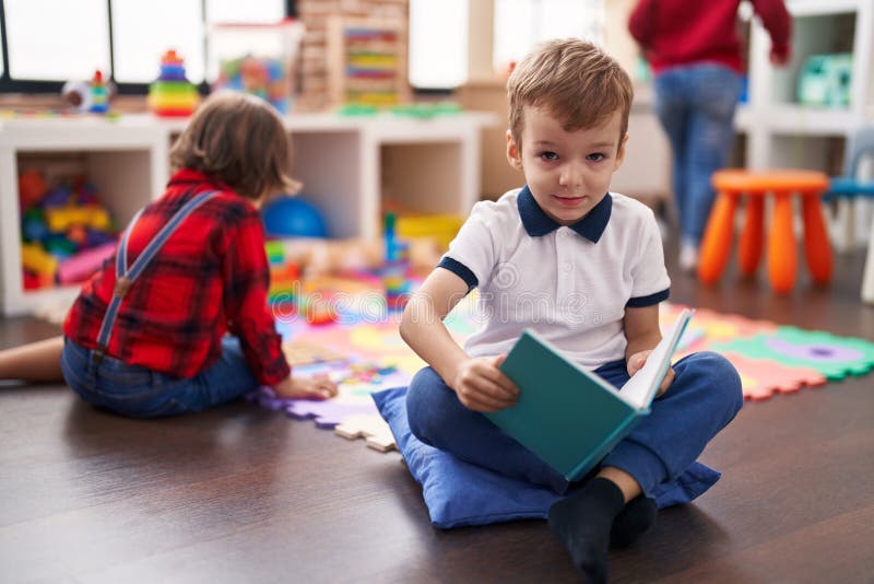 Two Kids Reading Book Sitting on Floor at Kindergarten Stock Photo ...
