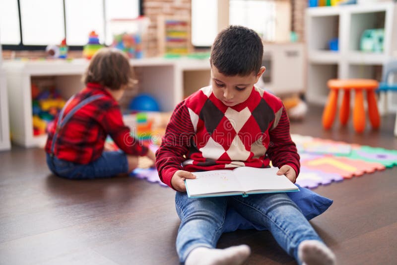 Two Kids Reading Book Sitting on Floor by Christmas Tree at Home Stock ...