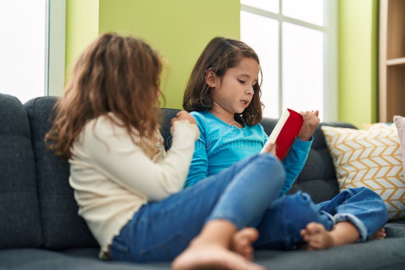 Two Kids Reading Book Sitting on Sofa at Home Stock Photo - Image of ...
