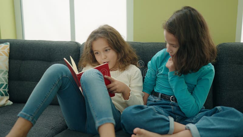 Two Kids Reading Book Sitting on Sofa at Home Stock Image - Image of ...