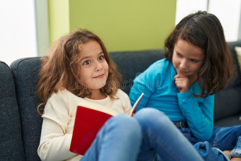 Two Kids Reading Book Sitting on Sofa at Home Stock Photo - Image of ...