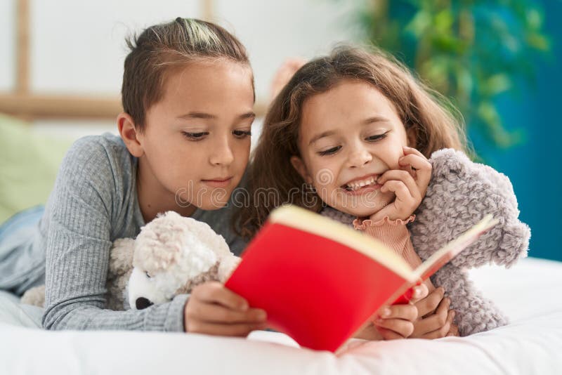 Two Kids Reading Story Book Lying on Bed at Bedroom Stock Photo - Image ...