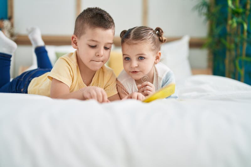 Two Kids Reading Story Book Lying on Bed at Bedroom Stock Photo - Image ...