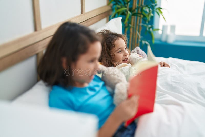 Two Kids Reading Story Book Sitting on Bed at Bedroom Stock Photo ...