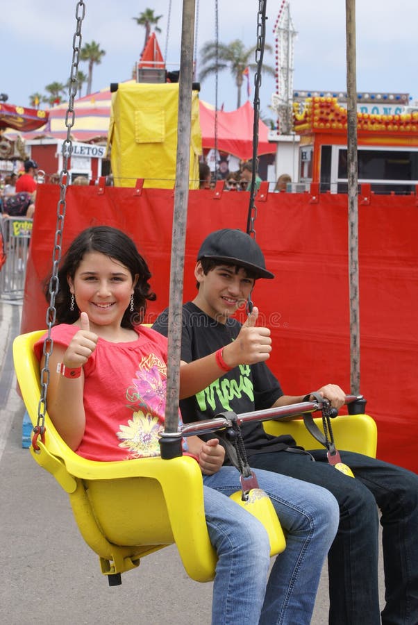 Two Kids Riding a Ride at the Fair or Carnival Stock Photo - Image of ...