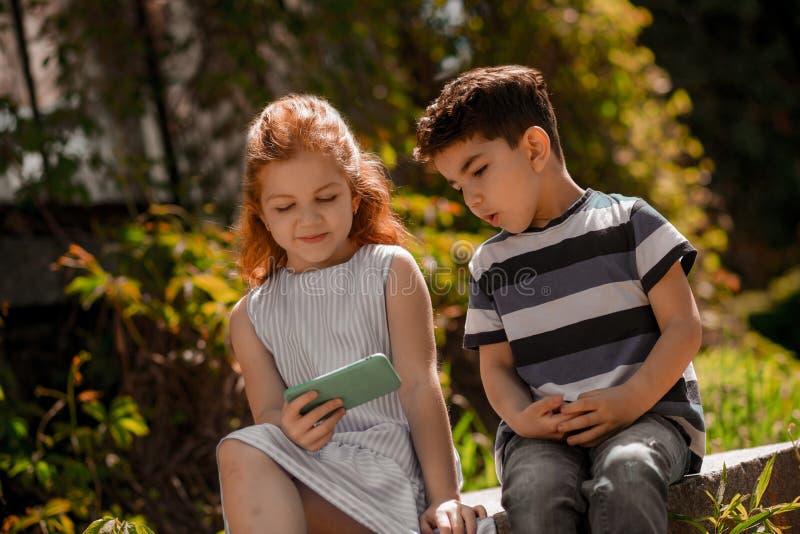 Two Kids Sitting Together and Watching Something Online Stock Photo ...