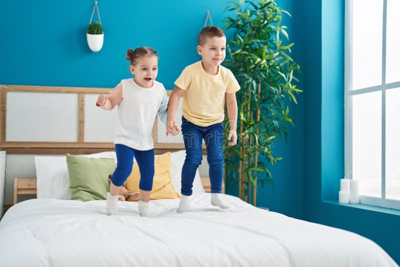 Two Kids Smiling Confident Jumping on Bed at Bedroom Stock Image ...