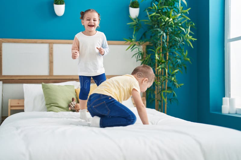 Two Kids Smiling Confident Jumping on Bed at Bedroom Stock Image ...