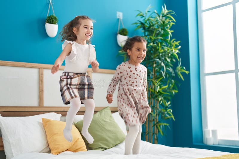 Two Kids Smiling Confident Jumping on Bed at Bedroom Stock Image ...