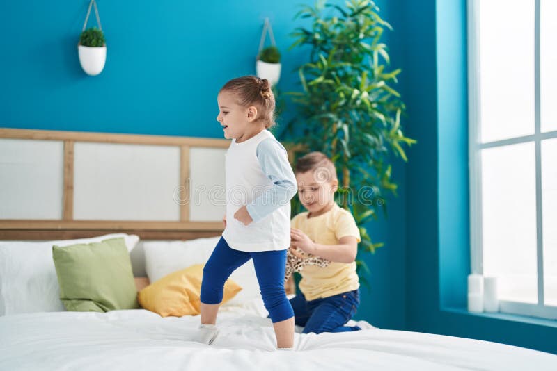 Two Kids Smiling Confident Standing on Bed at Bedroom Stock Photo ...