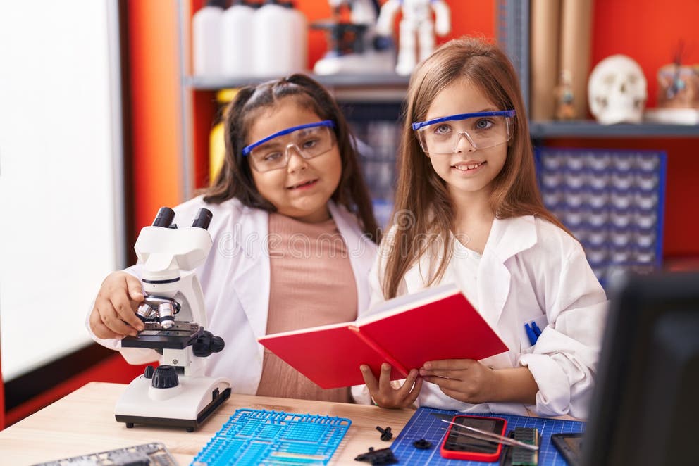 Two Kids Students Using Microscope Reading Notebook at Laboratory ...