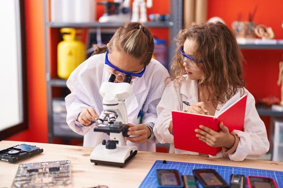 Two Kids Students Using Microscope Writing on Notebook at Laboratory ...