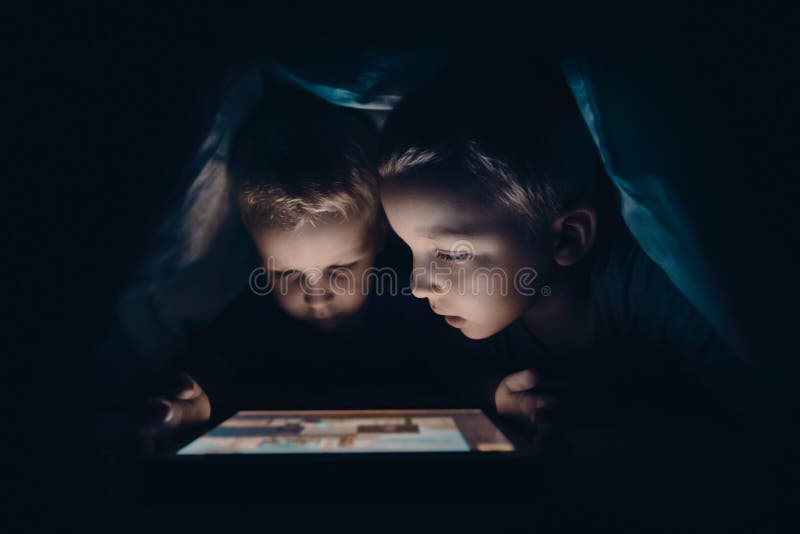 Two Kids with Tablet Computer in a Dark Room Stock Photo - Image of ...
