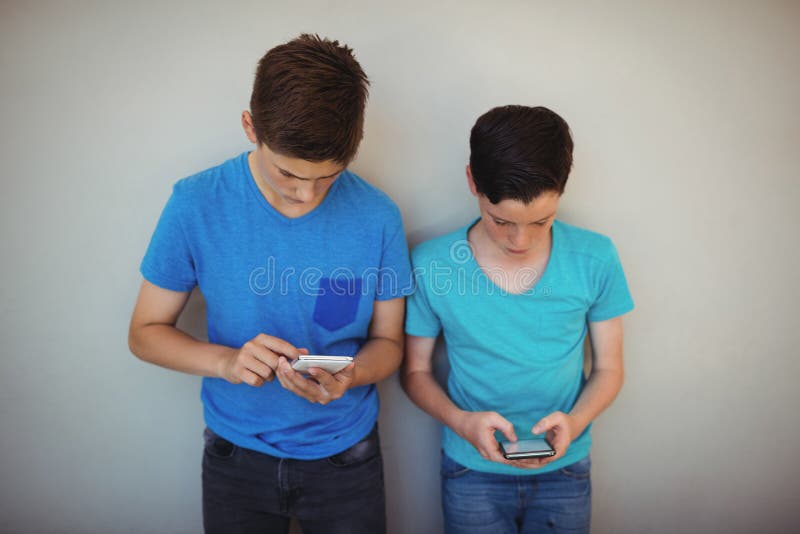 Two Kids Using Mobile Phone in Corridor at School Stock Image - Image ...