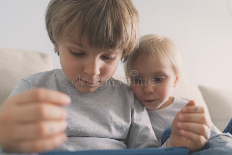 Two Kids Using Tablet on Sofa at Home Stock Image - Image of education ...