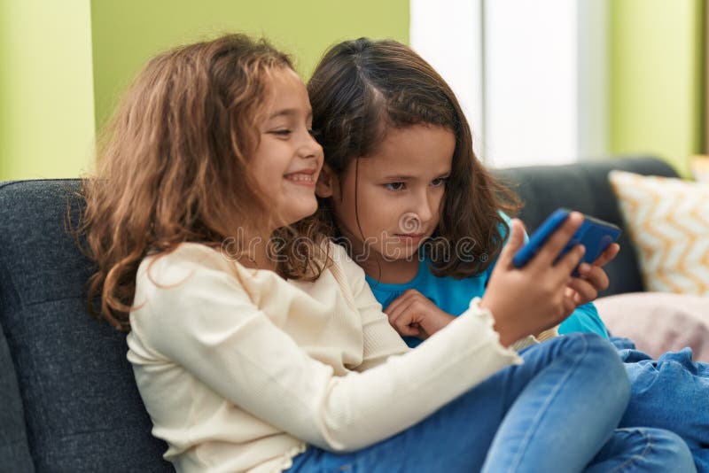 Two Kids Watching Video on Smartphone Sitting on Sofa at Home Stock ...