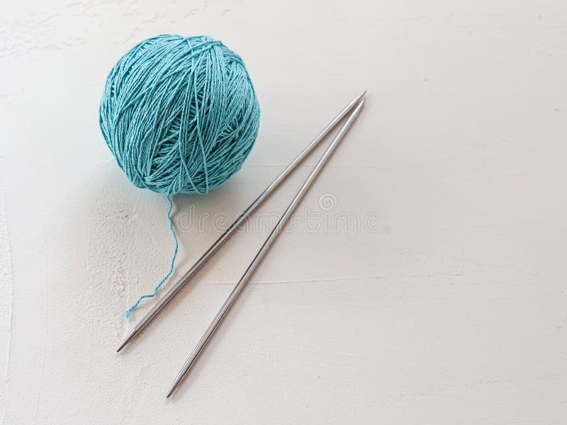 Two Knitting Needles and Blue Threads on a White Background Close-up ...