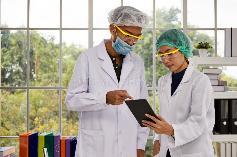 Two Lab Researchers Reviewing and Analyzing Data on Digital Tablet ...