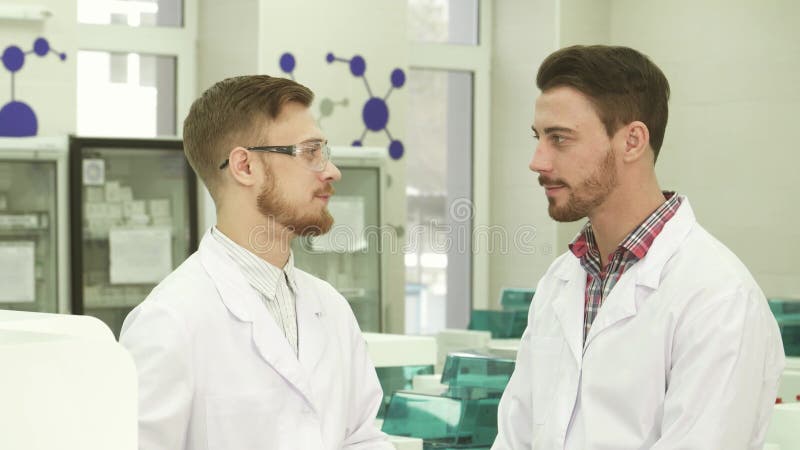 Two Laboratory Technicians Share a Light-hearted Conversation in a ...