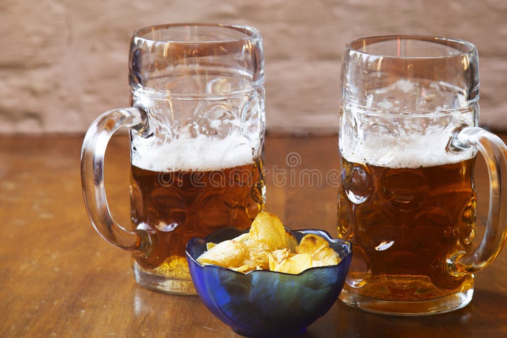 Two Large Mugs of Beer and Chips on a Wooden Table Stock Photo - Image ...