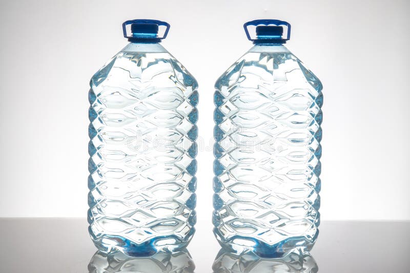 Two Large Plastic Water Bottles with Blue Caps and Textured Design ...