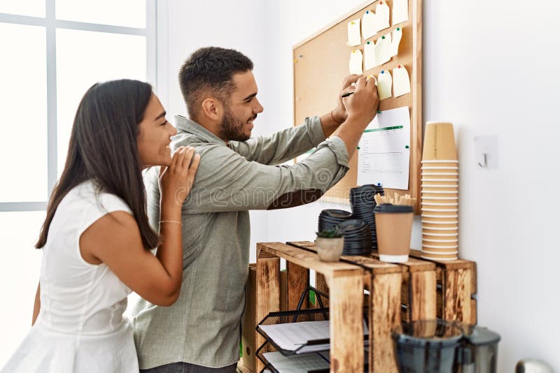 Two Latin Business Workers Smiling Happy Writing on Corkboard Working at the Office Stock Image ...