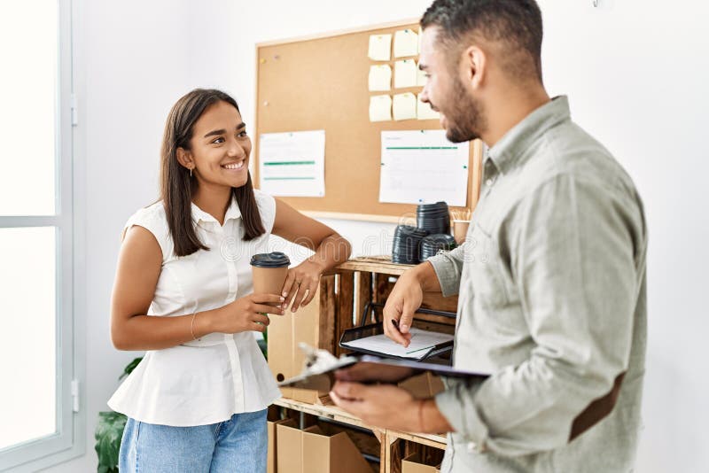 Two Latin Business Workers Writing on Clipboard Drinking Coffee at the ...